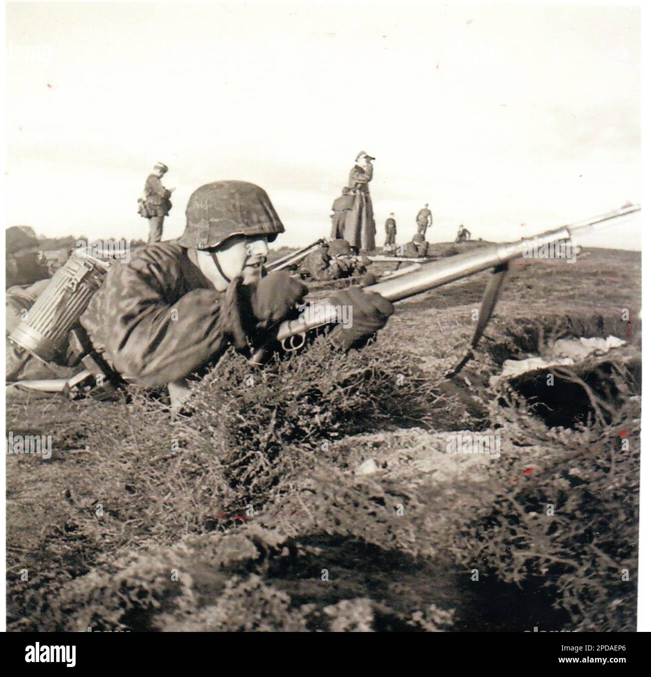 World War Two B&W photo German Soldier in a Camo Smock loads his rifle ...