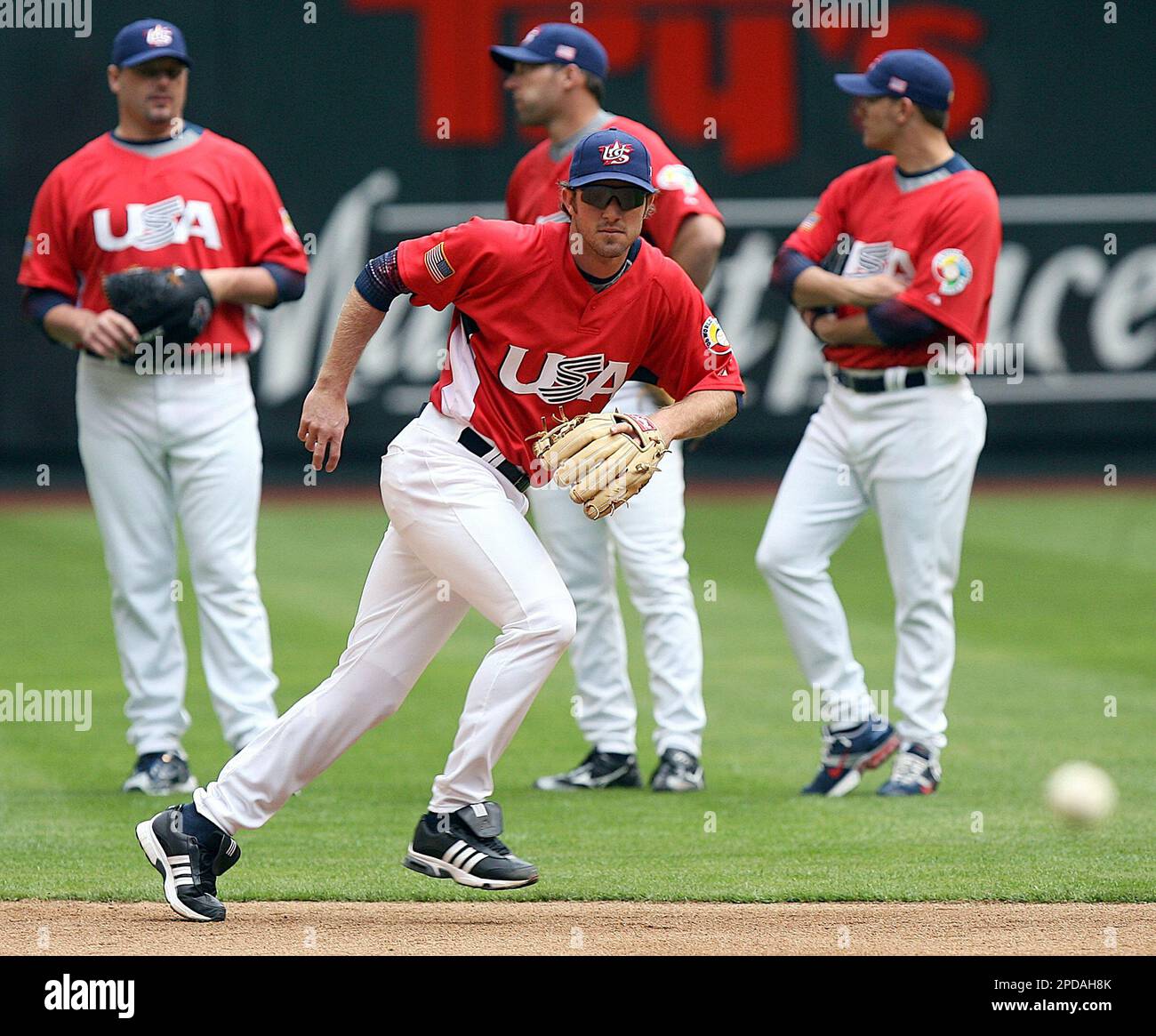 Team USA infielder Chase Utley, front, chases down a groundball in ...