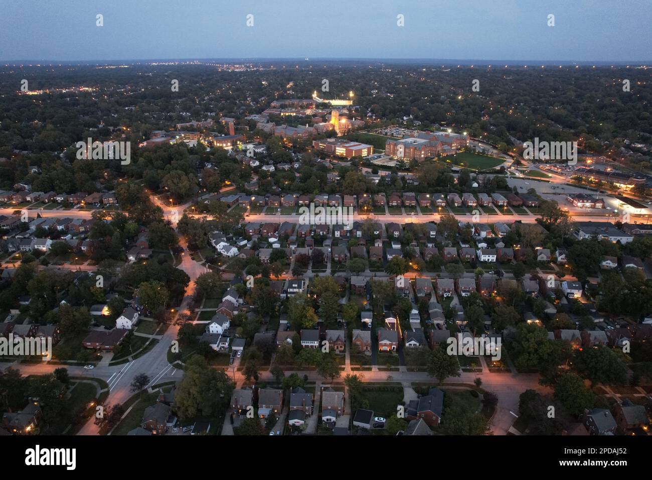An aerial view of a suburban town at night, illuminated by streetlights ...