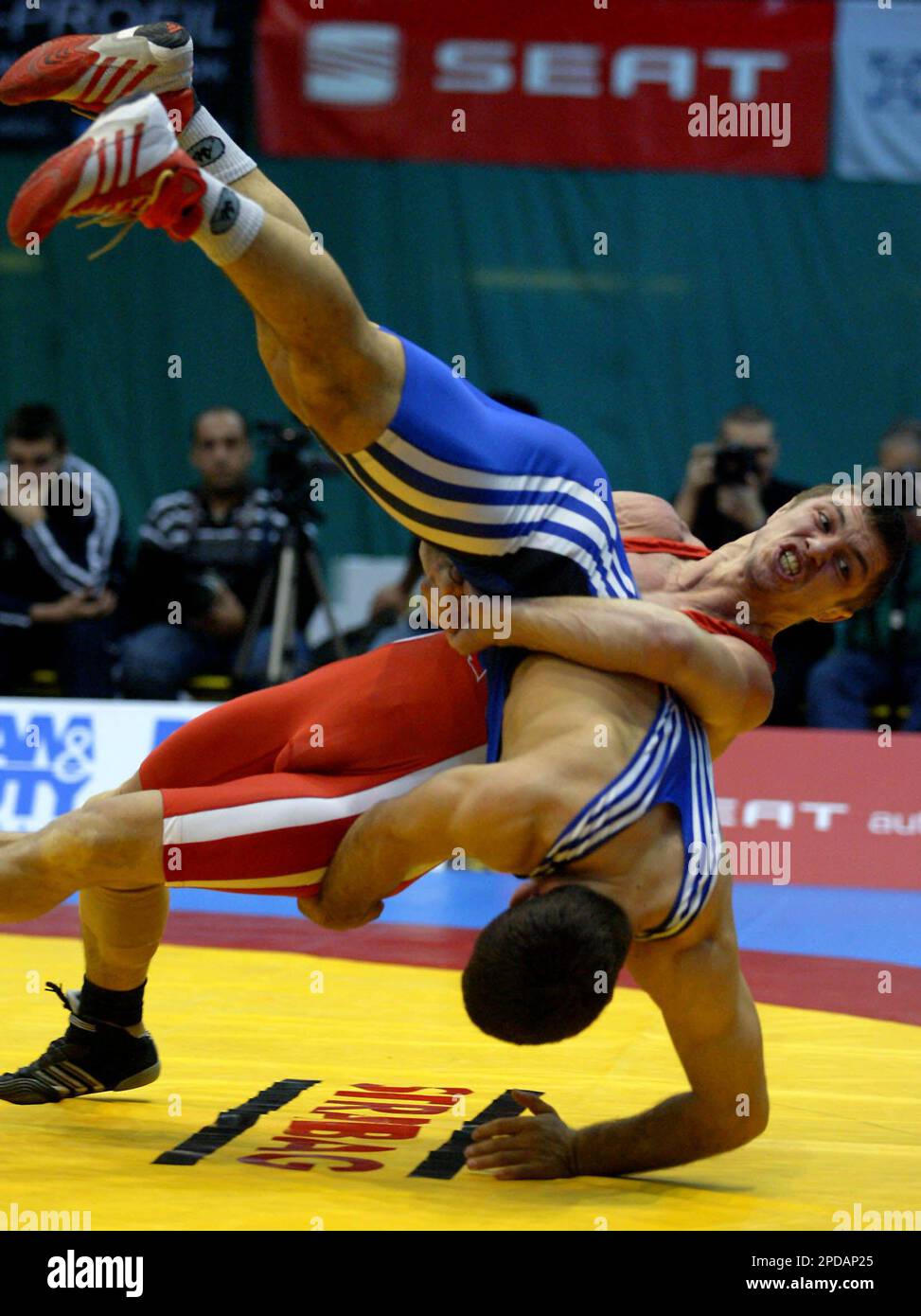 Sergei Kovalenko of Russia (in red) lifts Seref Eroglu of Turkey during their fight in the final ...
