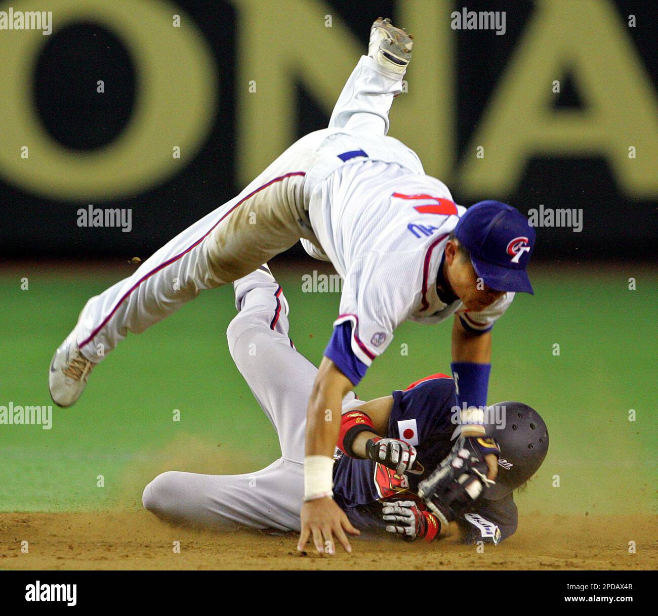 Taiwan's infielder Hu Chin-Lung, top, leaps over Japan's Tsuyoshi ...