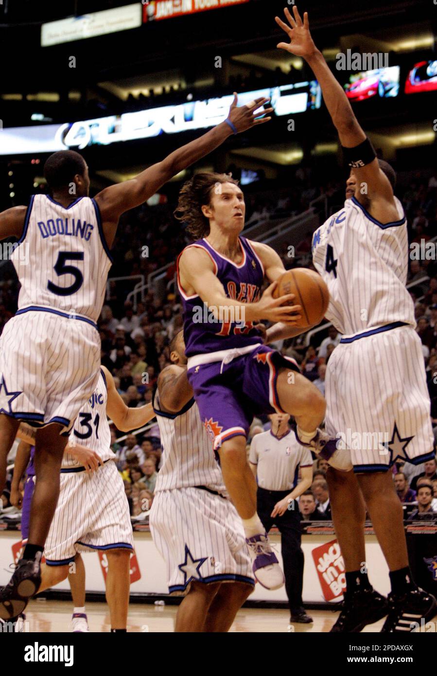 Phoenix Suns' Steve Nash goes for a layup between Orlando Magic's Keyon ...