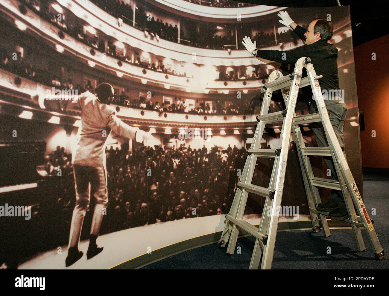 Country Music Hall of Fame curator Mick Buck, right, applies a mural of ...