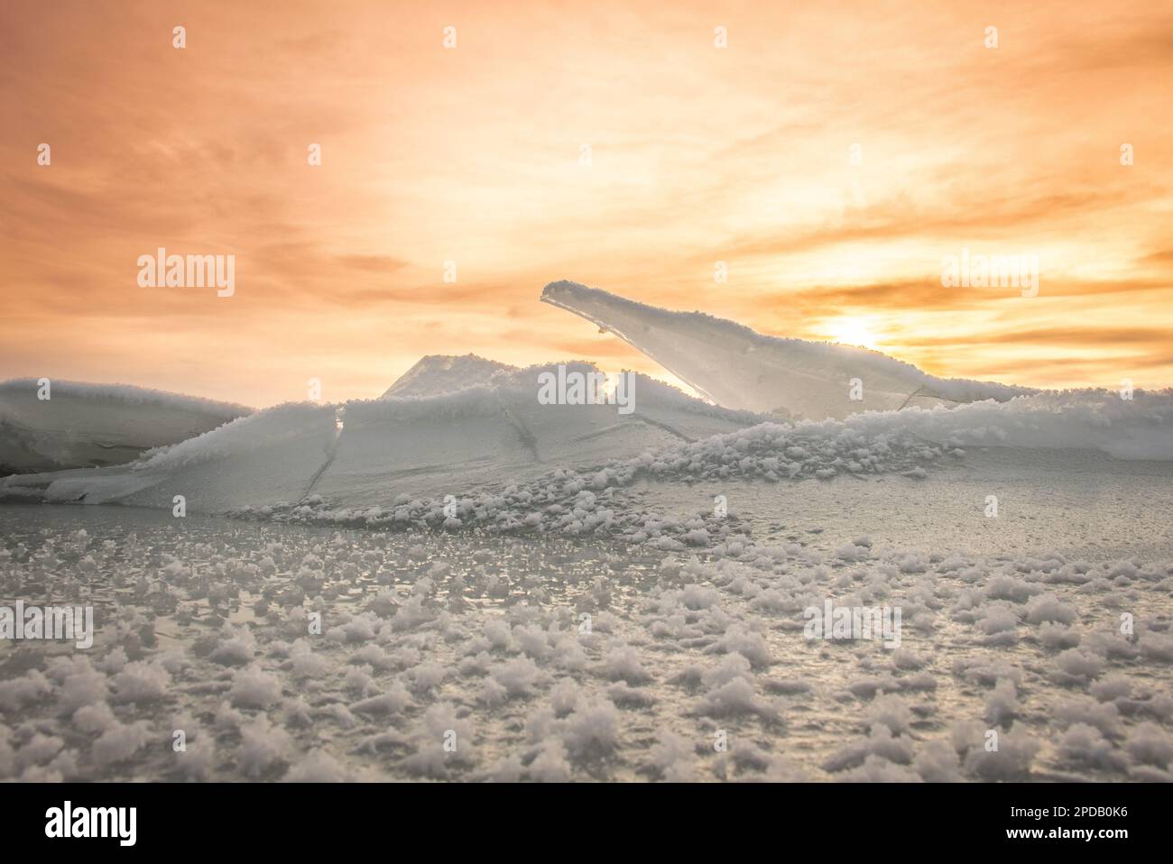 Low angle of ice drift on lake with sun peaking over ice edge Stock ...