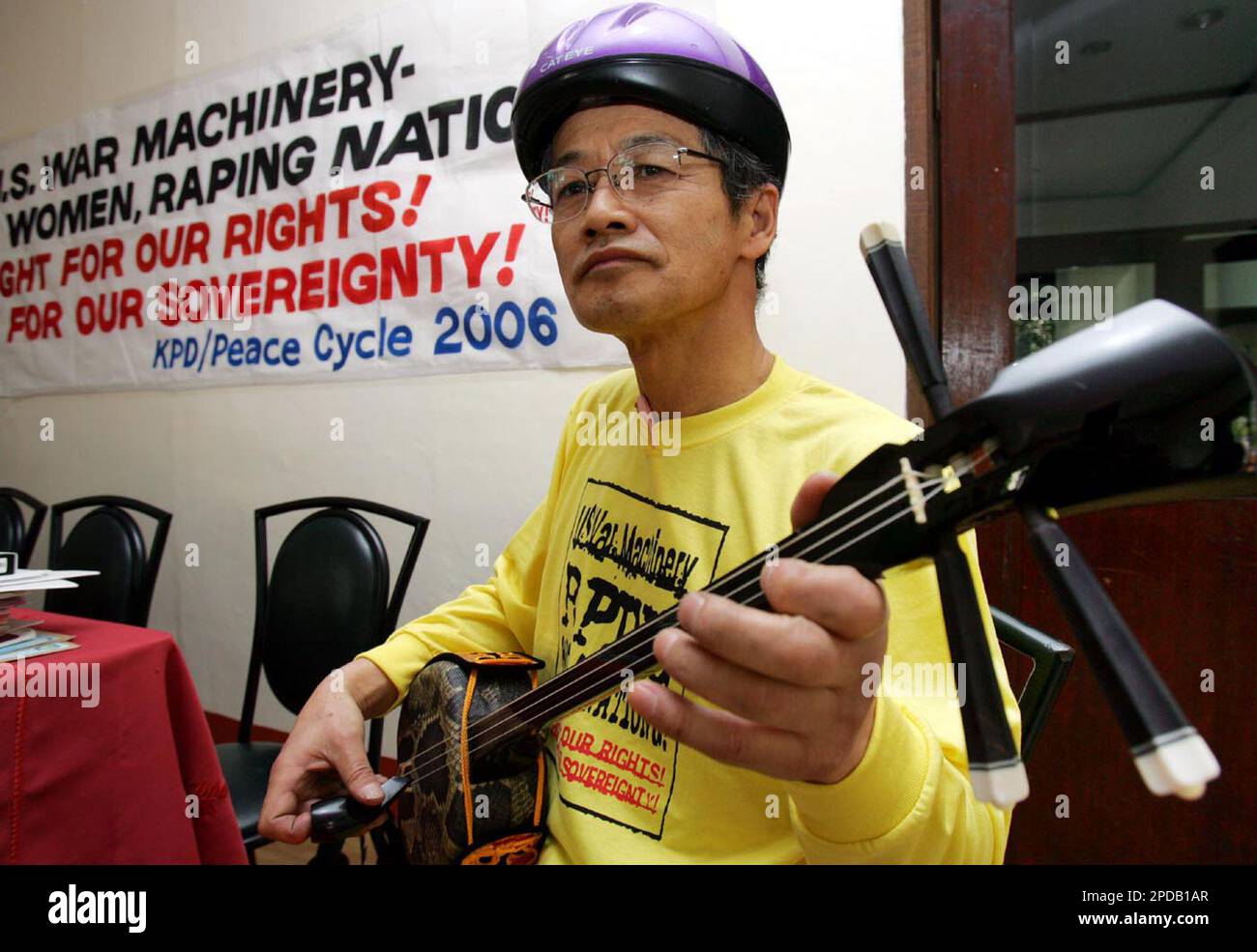 Japanese peace cyclist Ichiro Hiwata plays the "sanshin" or a ...