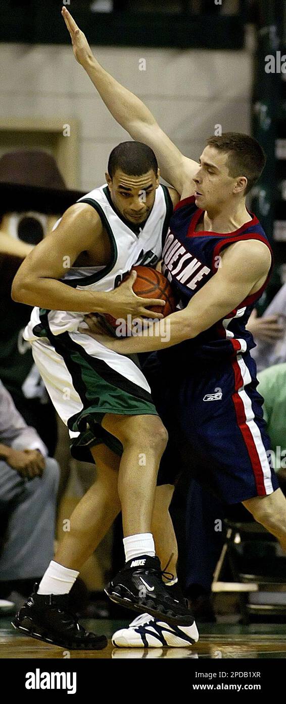 Charlotte's Marcus Bennett, left, is swarmed by Duquesne's Adam Souply ...