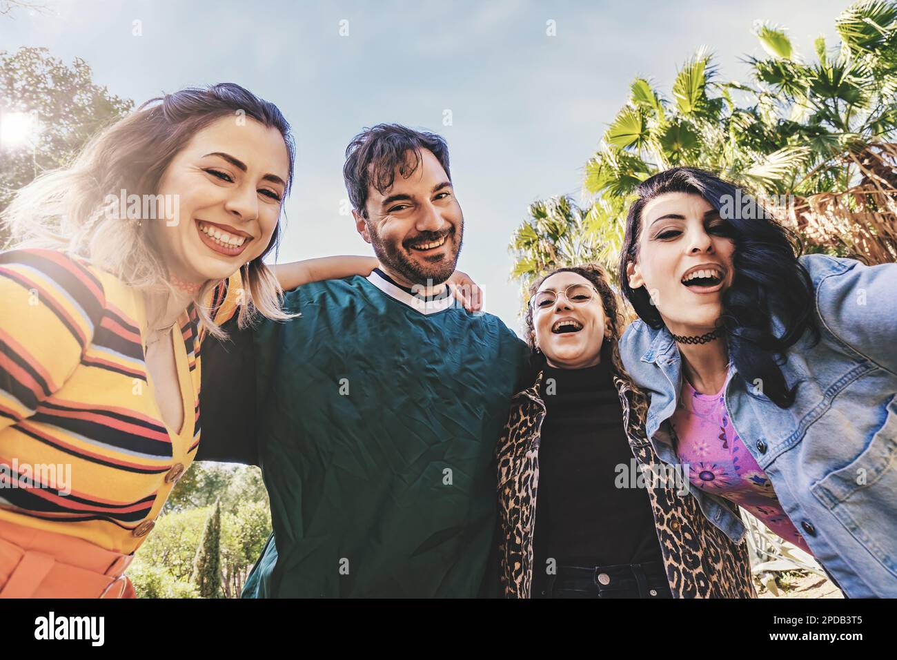 A group of young friends in vintage 90s casual clothes smiling and ...