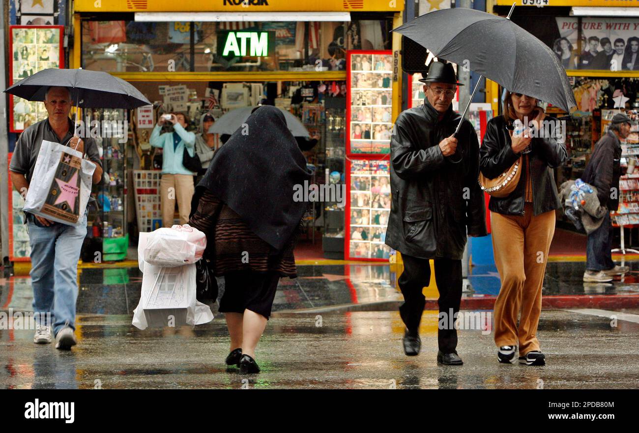 Pedestrians cross Hollywood Blvd. in the rain Monday, Feb. 27, 2006, in ...