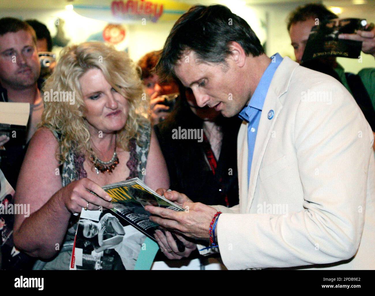Actor Viggo Mortensen, right, signs pictures a for fan as he arrives at ...