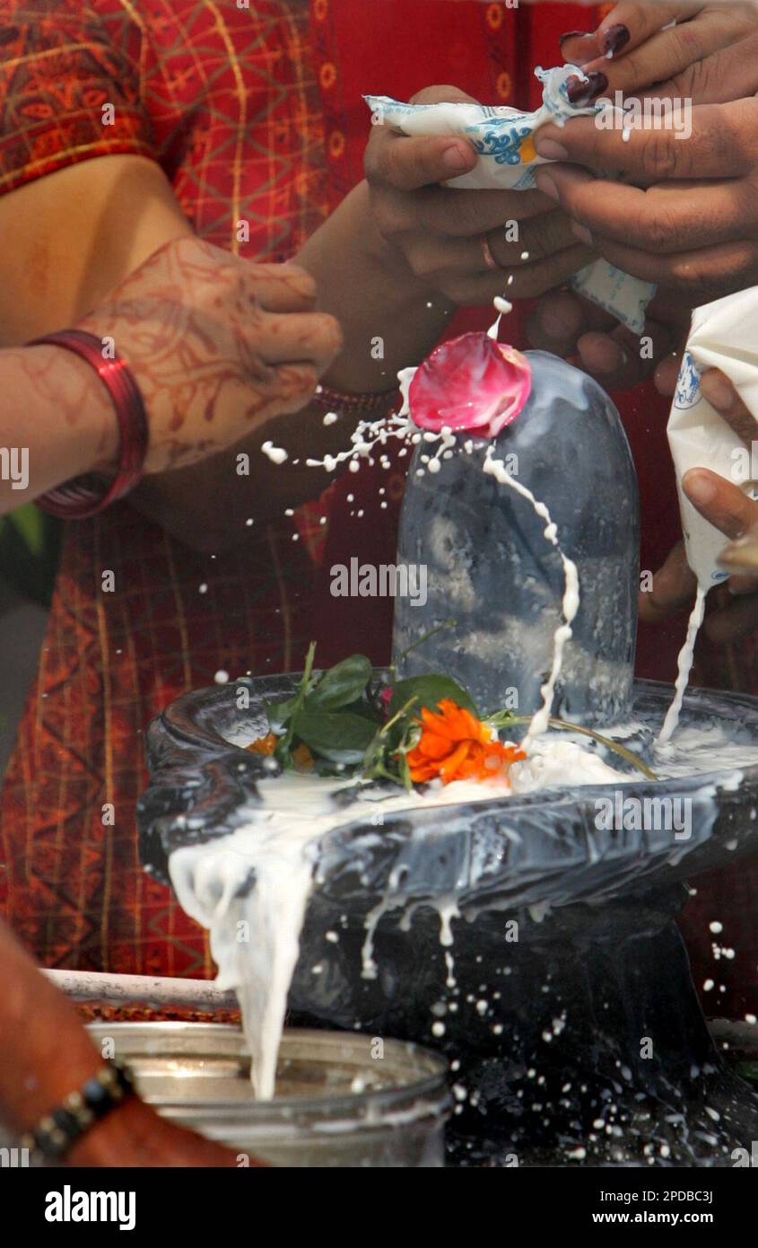 Devotees pour milk on a Shivling, an iconic representation of Hindu God ...
