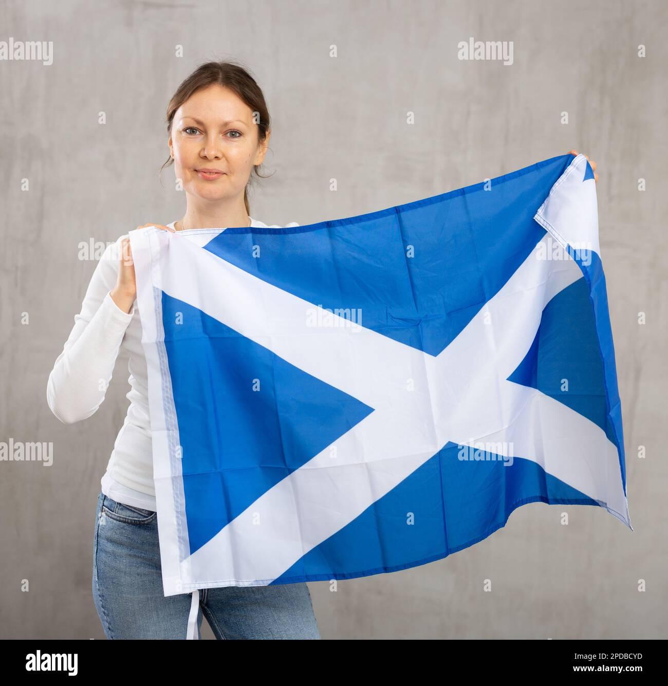 Happy smiling woman proudly displaying scottish flag Stock Photo - Alamy