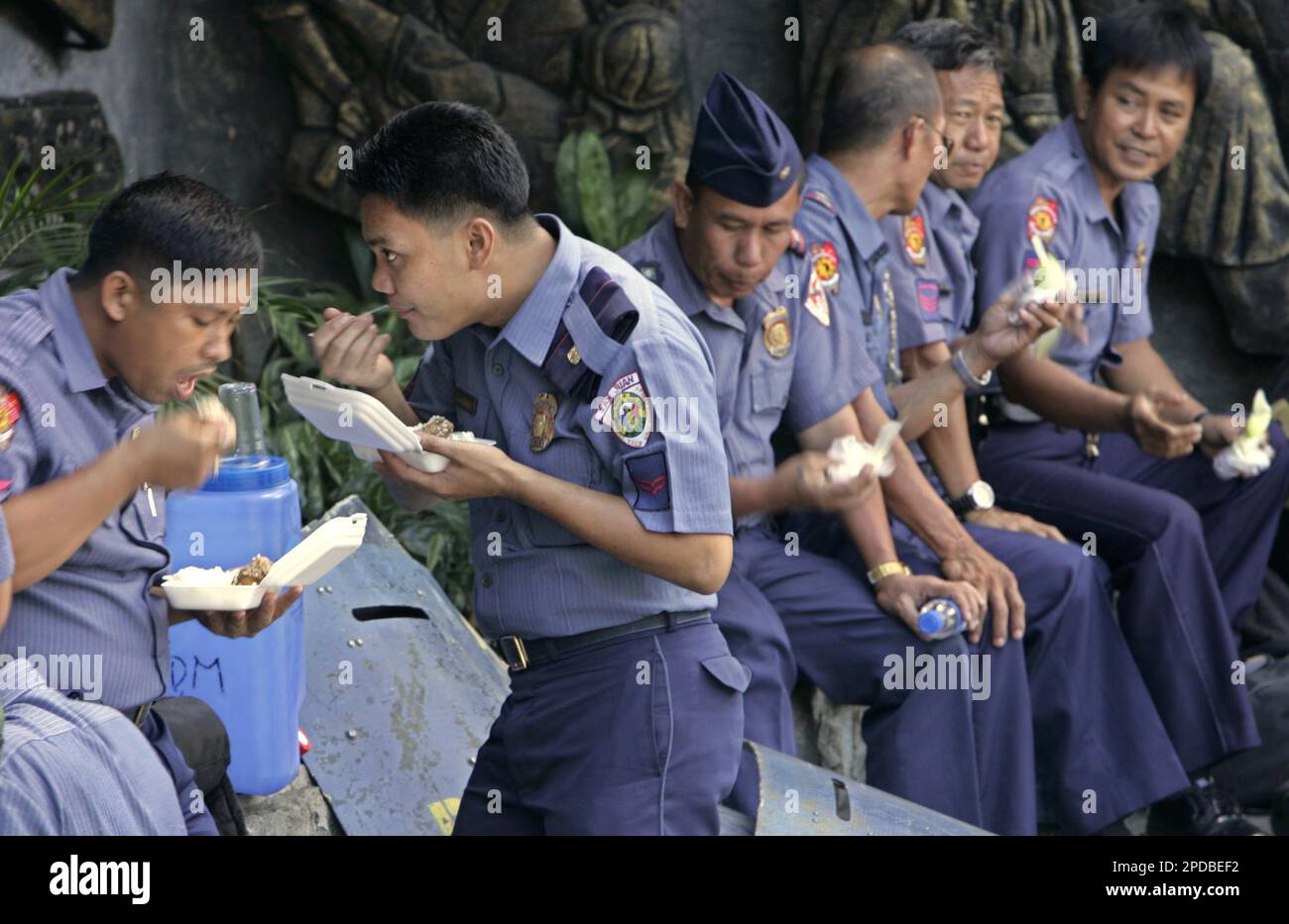 Police officers eat lunch at the Edsa shrine that was a focal point of ...