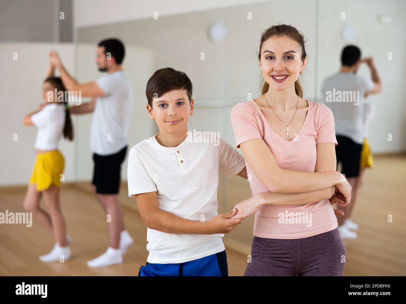 Cheerful woman practicing active dance in pair with tween son Stock ...