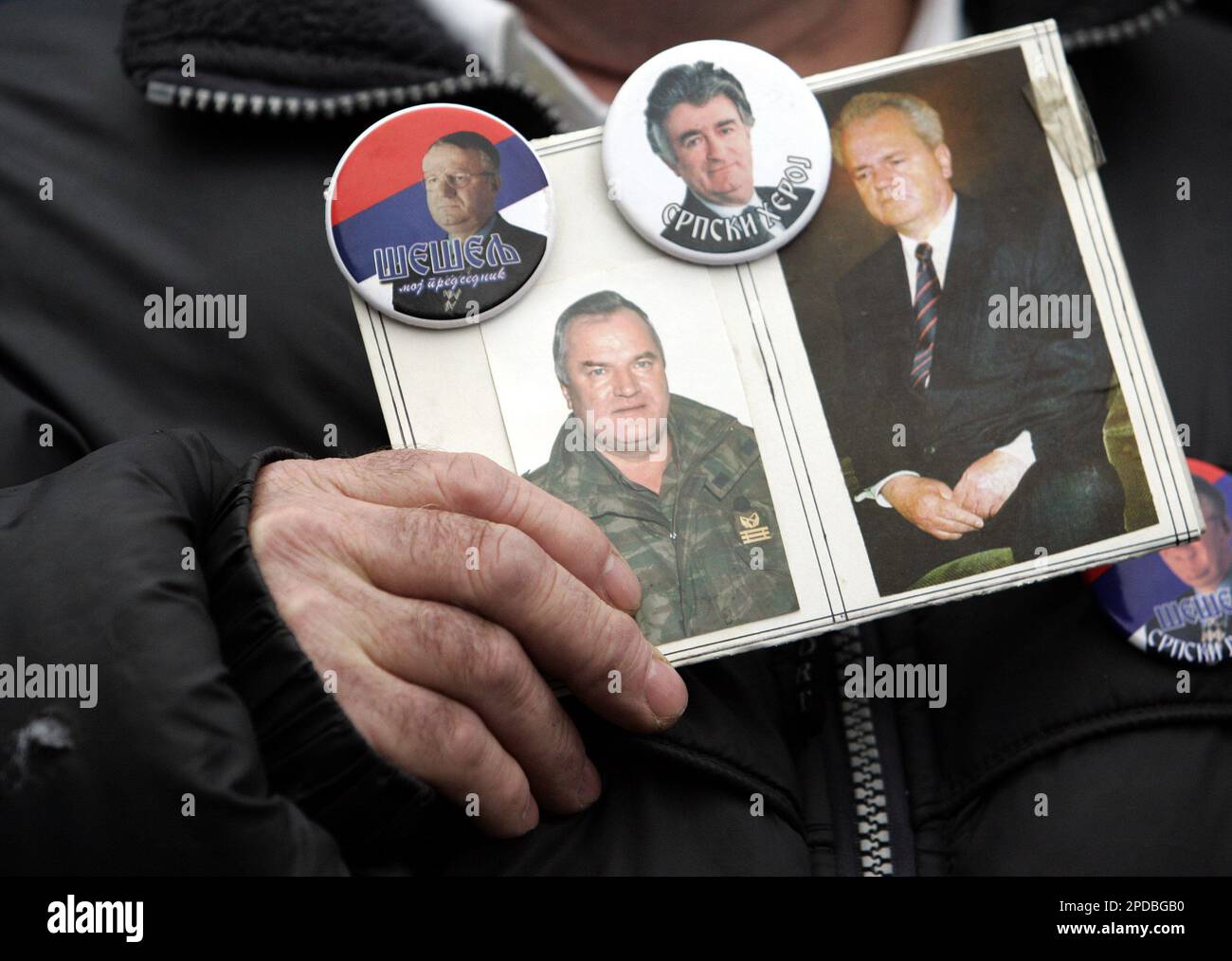 A Serbian Radical Party supporter shows pictures of former Bosnian Serb ...