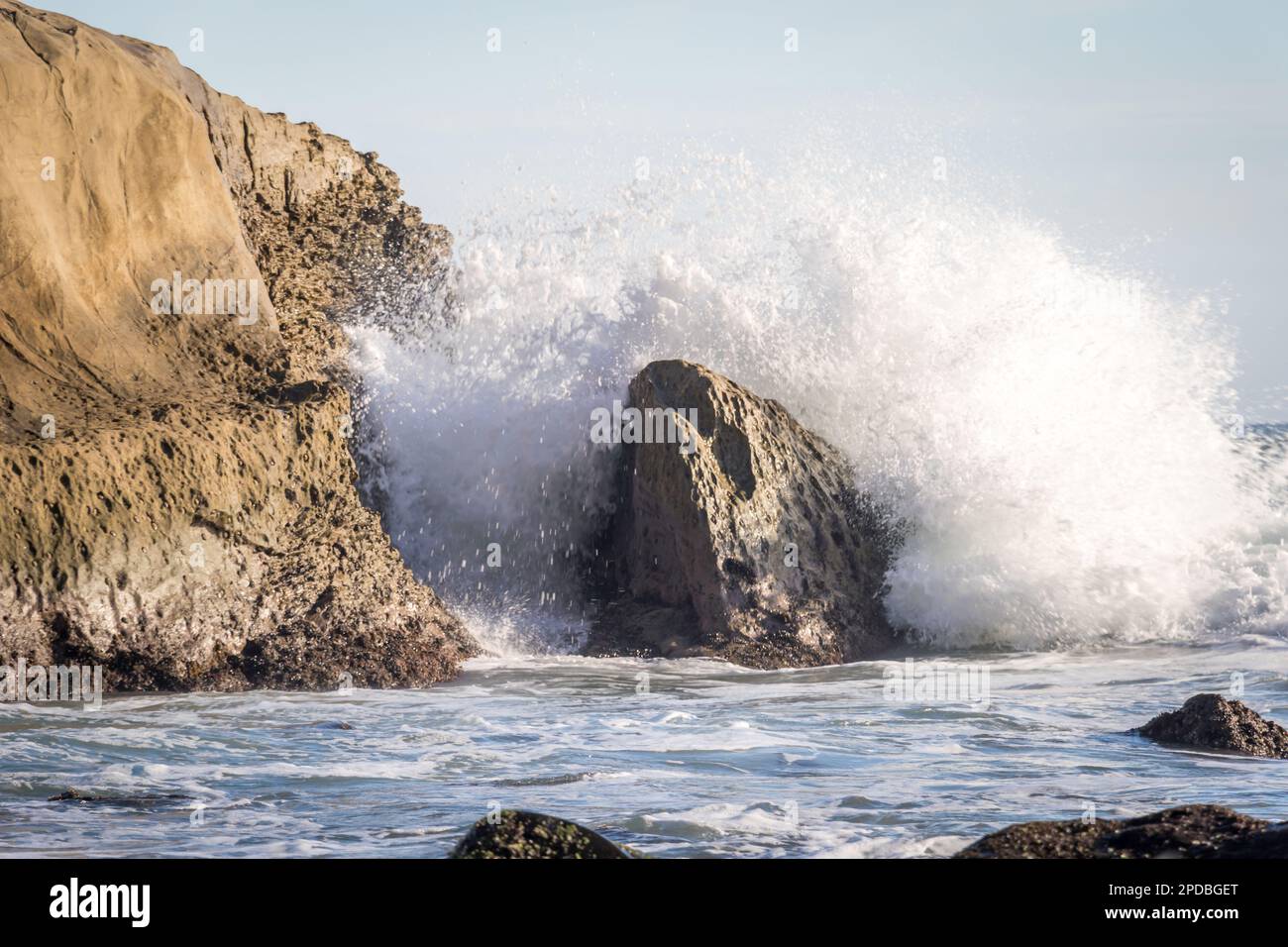 Ocean Wave Crashing Over Rocks on Coast Stock Photo - Alamy