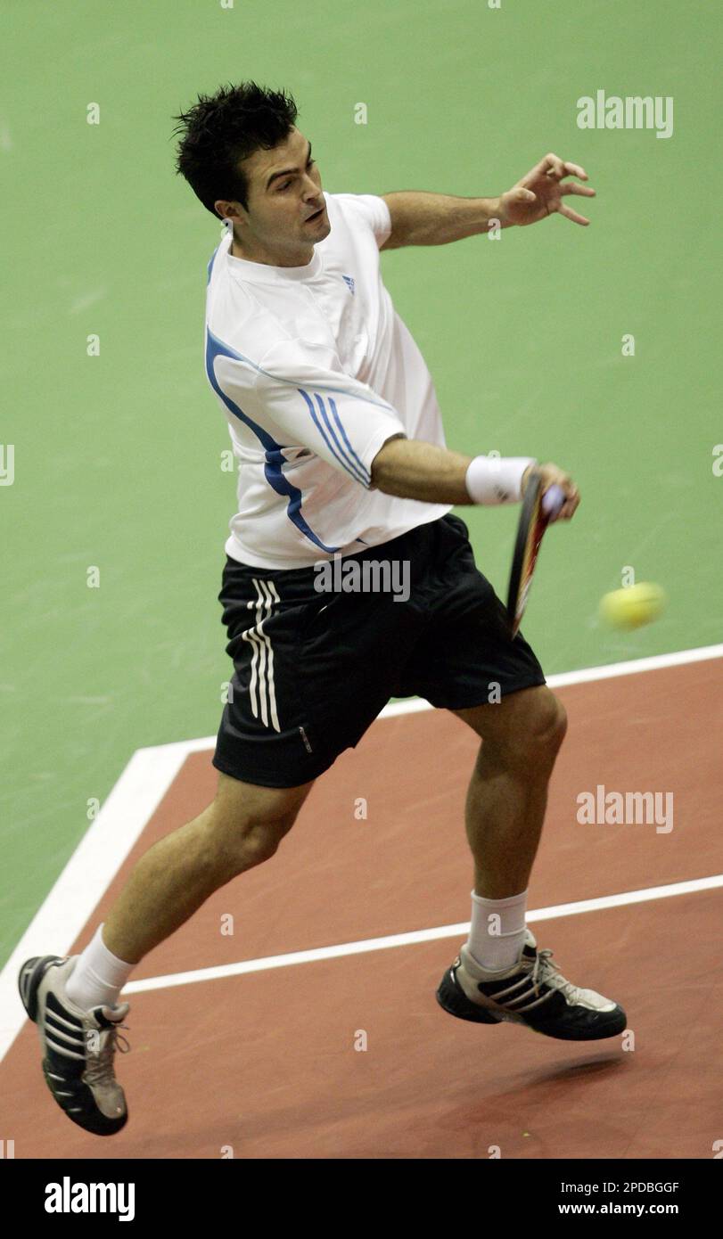 Italy's tennis player Daniele Bracciali returns the ball to Nikolay ...