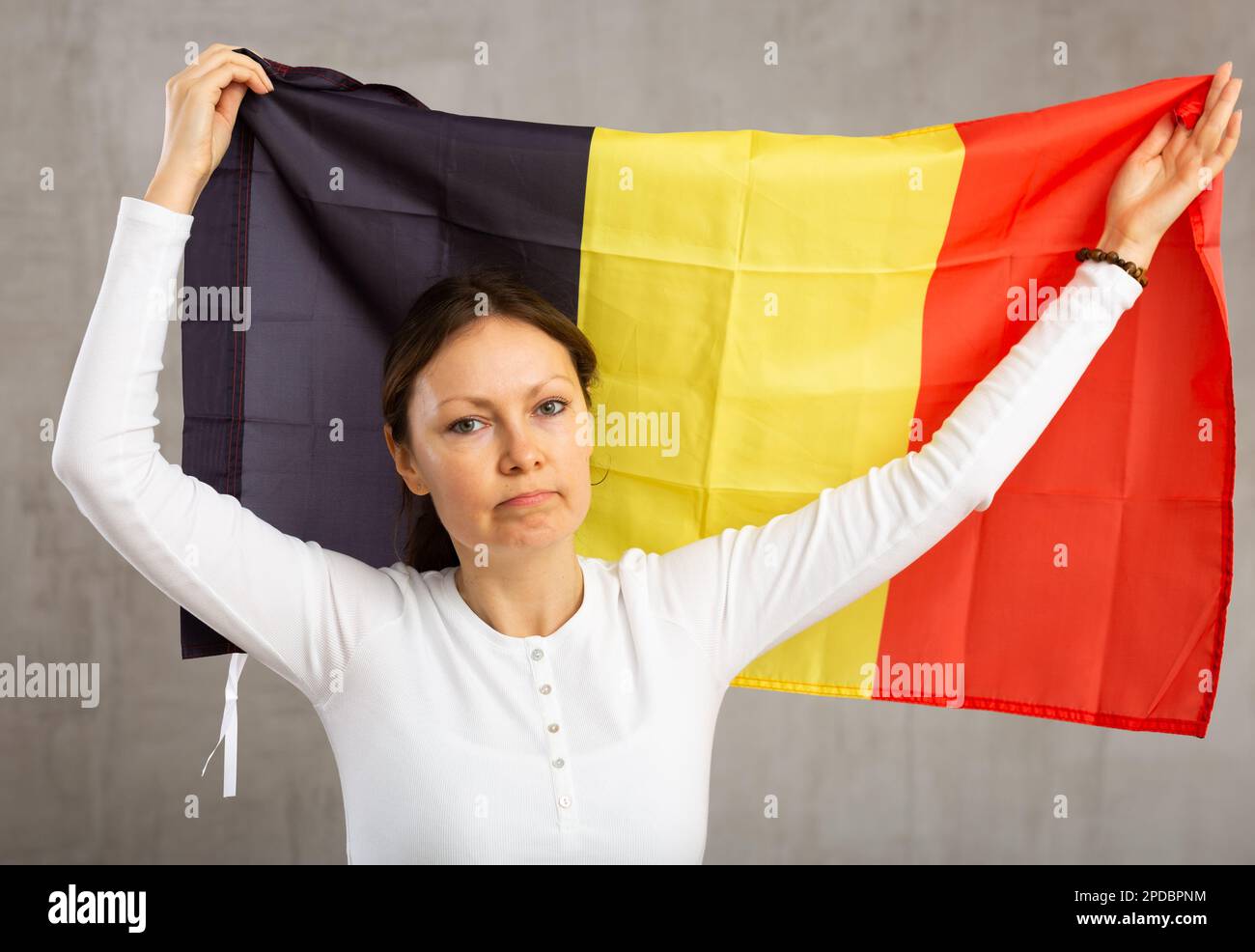 Unhappy sad middle-aged woman waving national flag of Belgium while ...