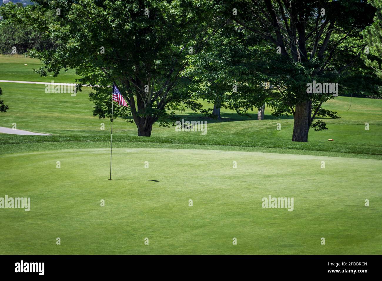Green on golf course with hole pin American Flag Stock Photo - Alamy