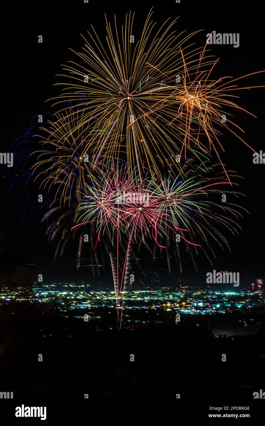 Long exposure of colorful aerial fireworks exploding over over city ...