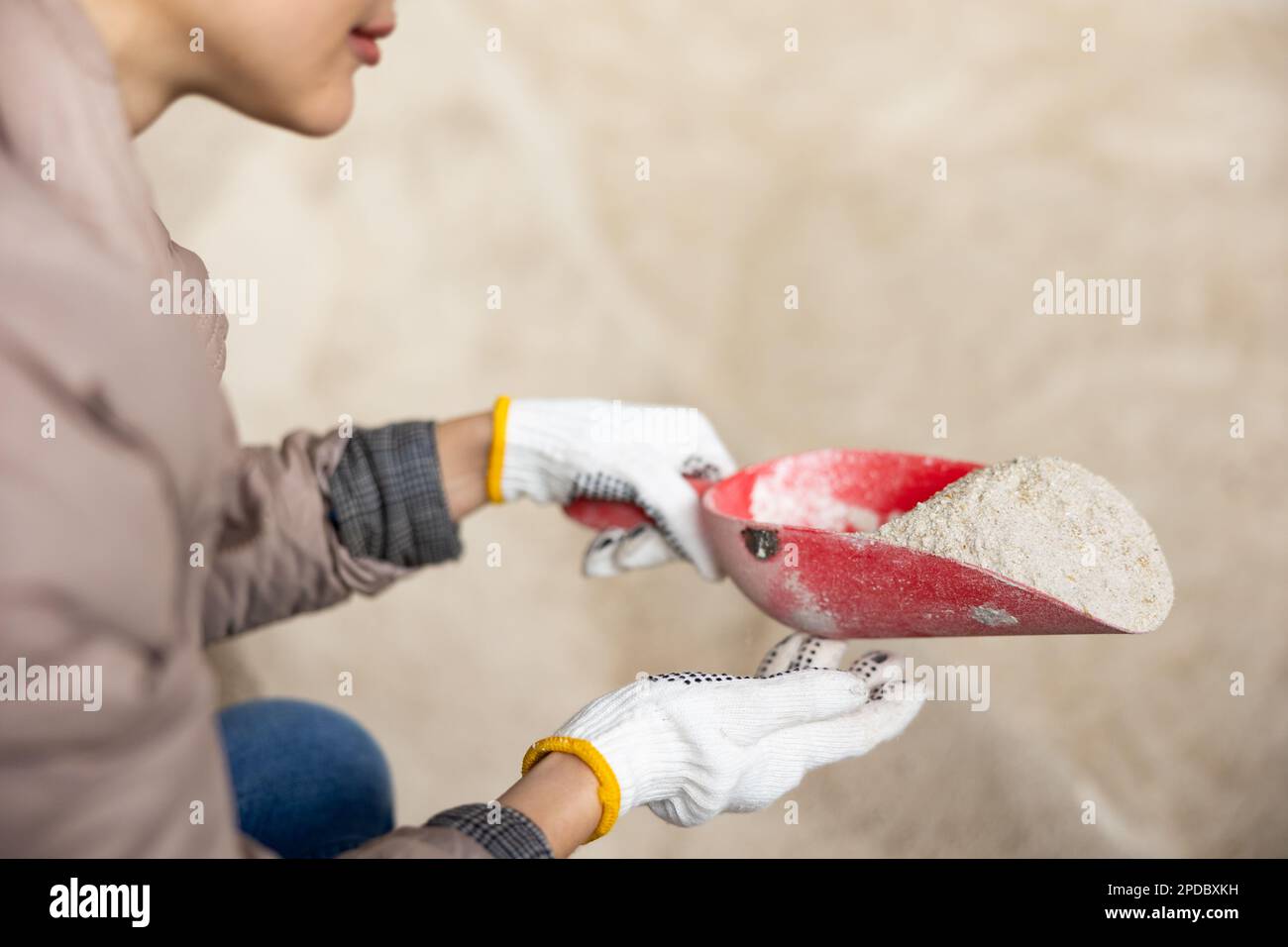 Female farmer scooping up maize meal from pile with scoop Stock Photo ...