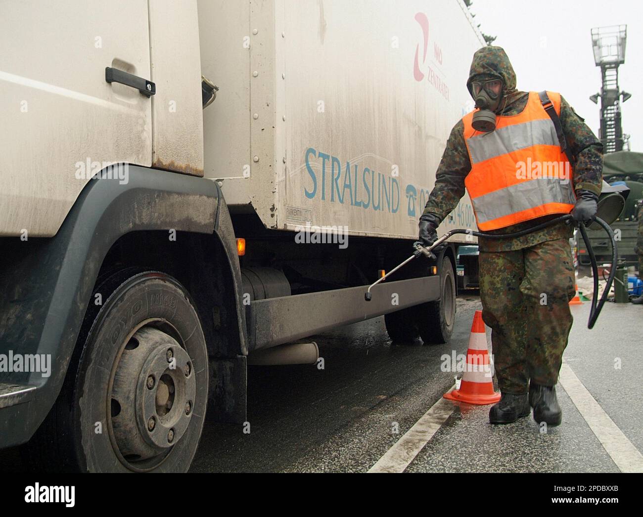 Special forces of the German army wearing gas masks spray disinfectant ...
