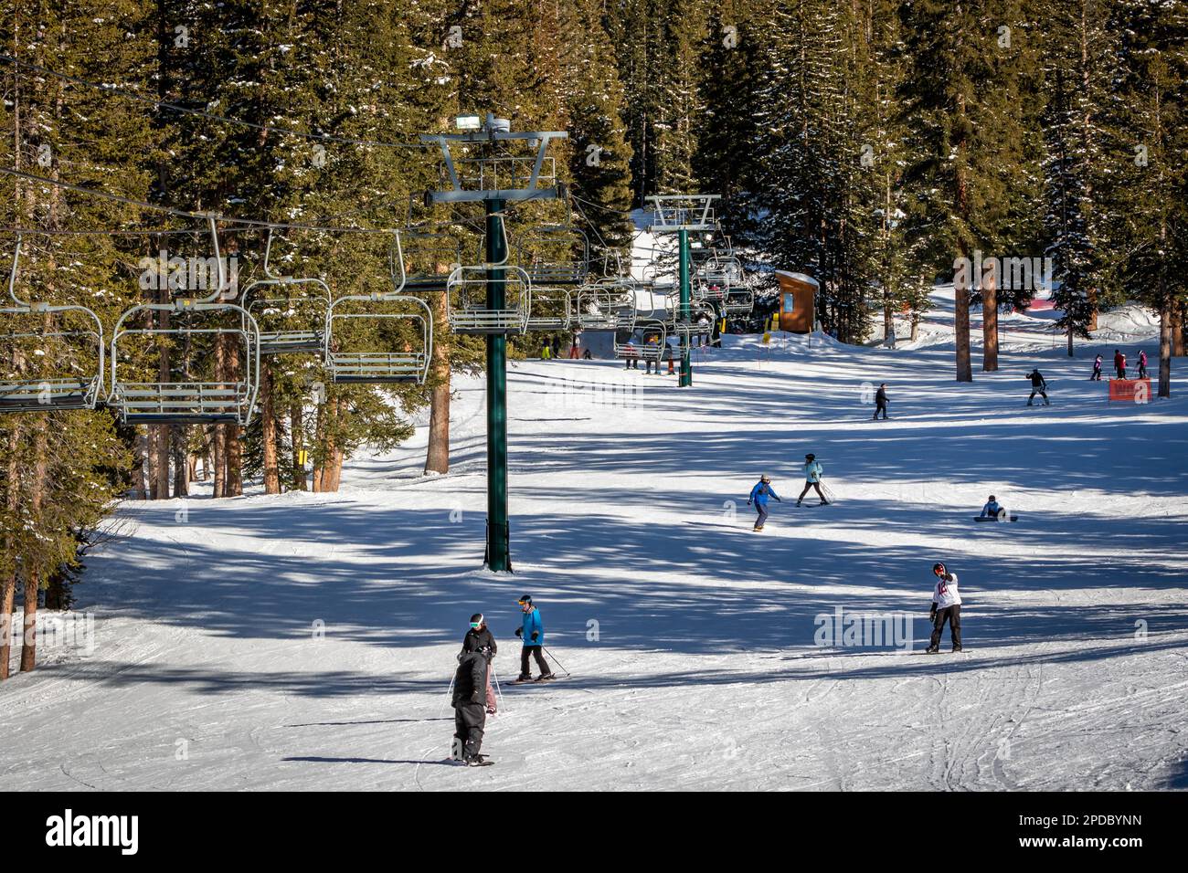 People Riding Down Mountain Slope at Ski Resort with Skis and ...