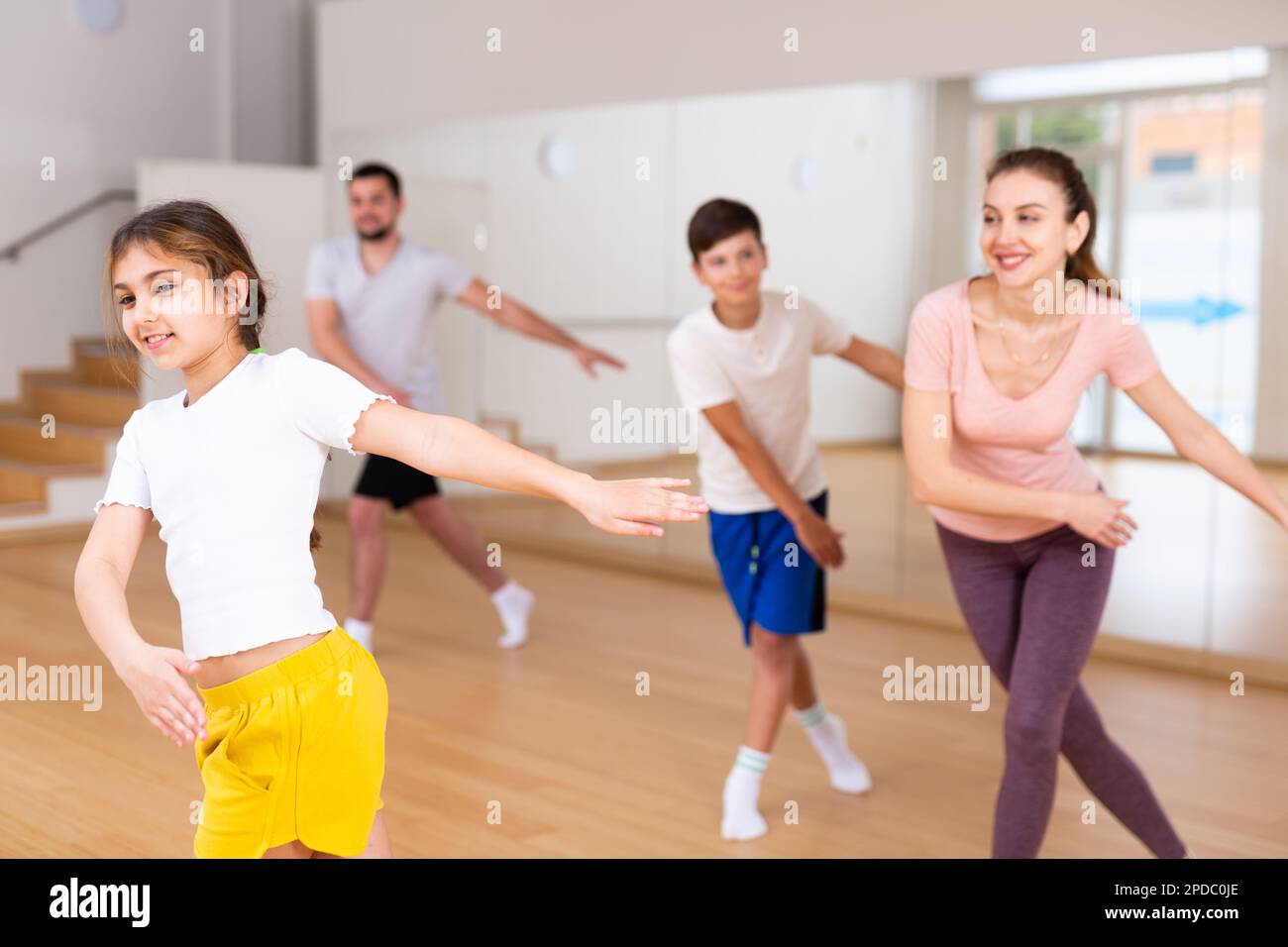 Girl dancing modern dance with family in gym Stock Photo - Alamy