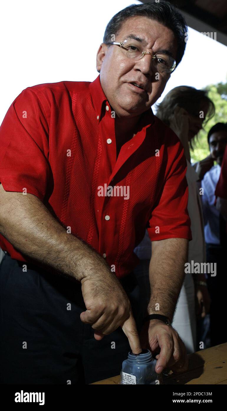Paraguayan President Nicanor Duarte, left, puts his finger in ink after ...