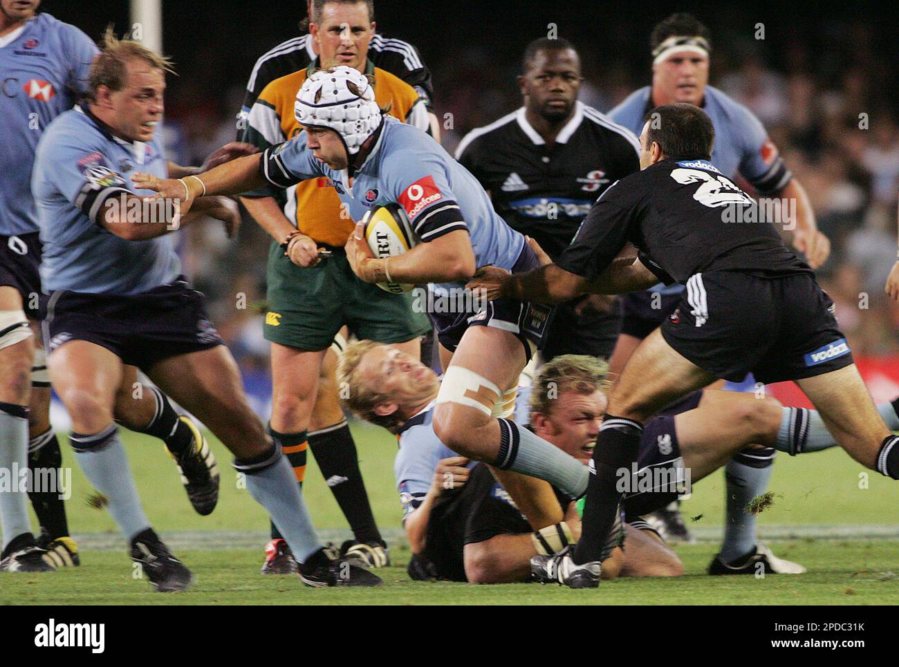 Waratahs Stephen Hoiles, center, breaks through as Stormers Neil De ...