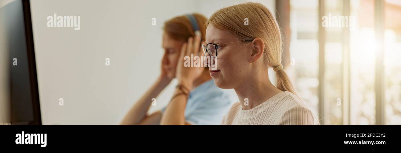 Focused university student using computer studying in computer room ...