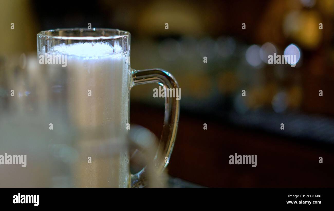 detail of a mug of pils beer with white foam on a brewery table waiting ...