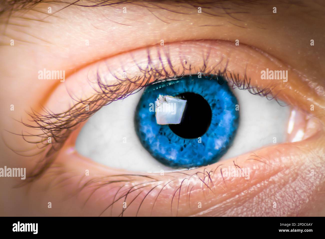 Extreme close up a girl’s eye that is colored blue and looking at the ...
