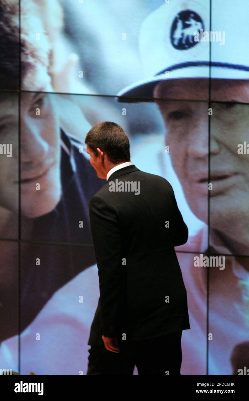 Jamie Packer, front, walks past a giant screen with a picture of ...