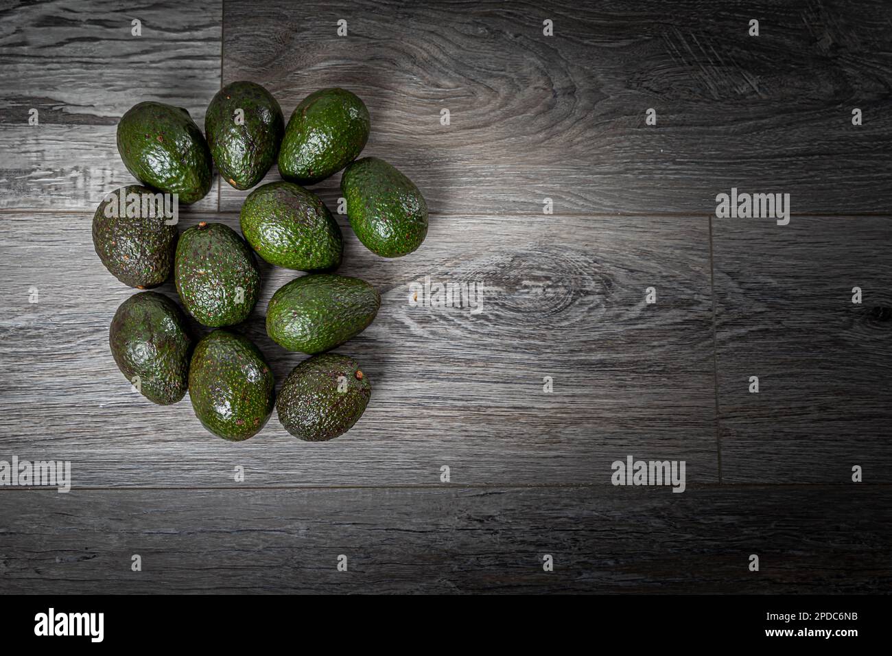 Group of Avocados on a Grey Wood Table Surface With Circle of Light on ...