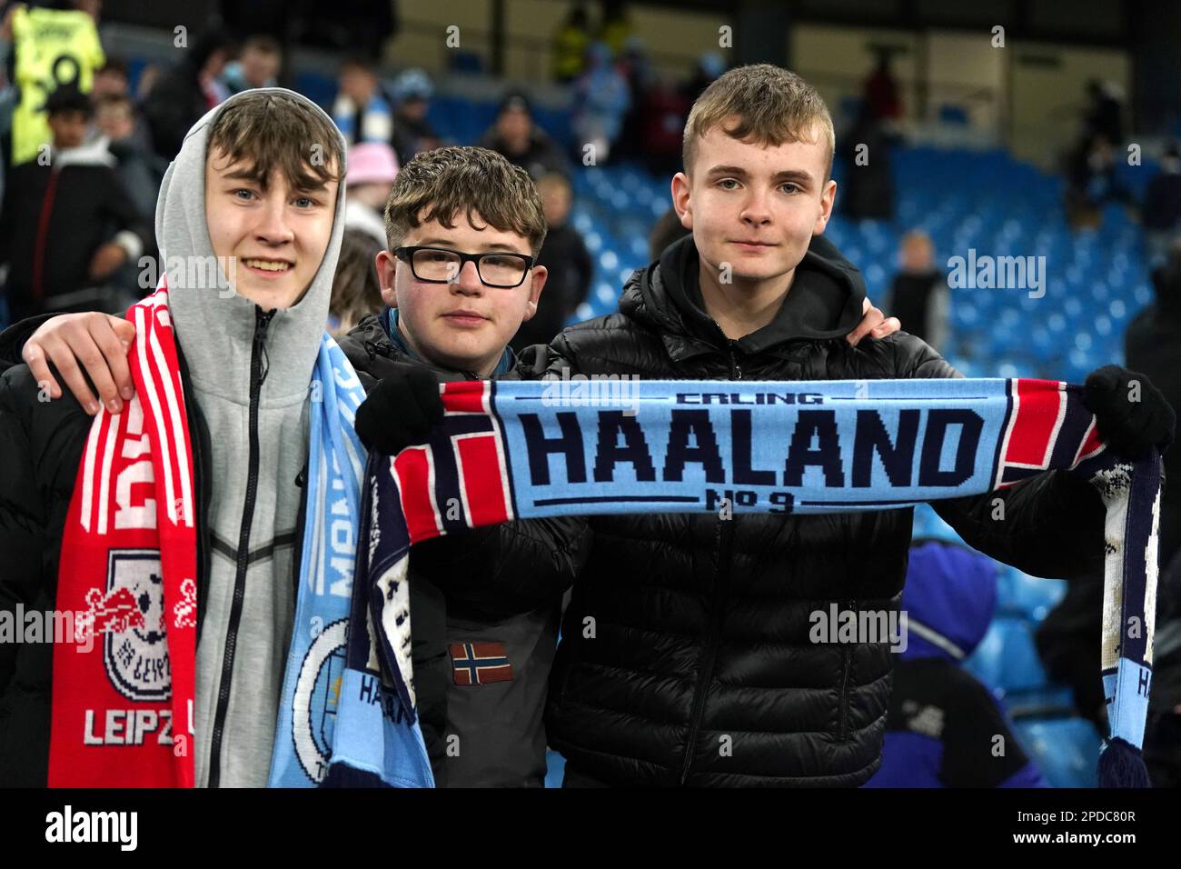 A Manchester City fan holds up a scarf with Manchester City's Erling ...