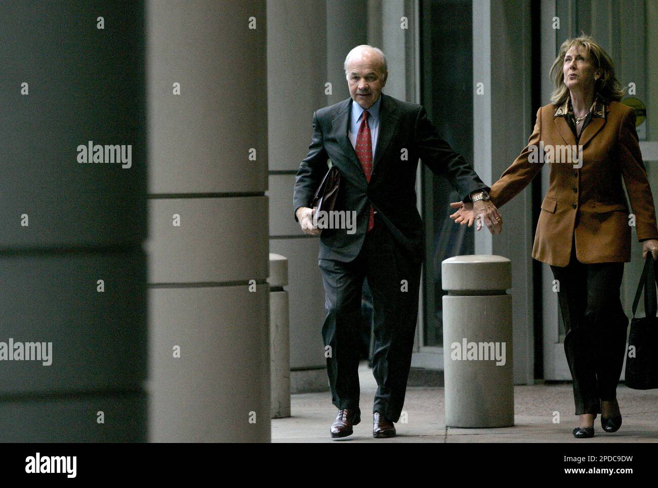 Former Enron CEO Kenneth Lay reaches for his wife Linda's hand as they ...