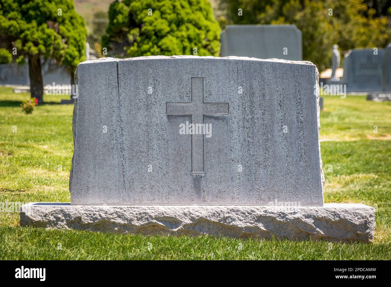 Granite headstone decorated with a large Christian cross at a cemetery ...