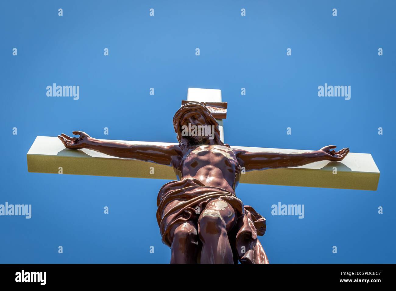 Gold colored statue at a cemetery of Jesus Christ hanging on the cross ...