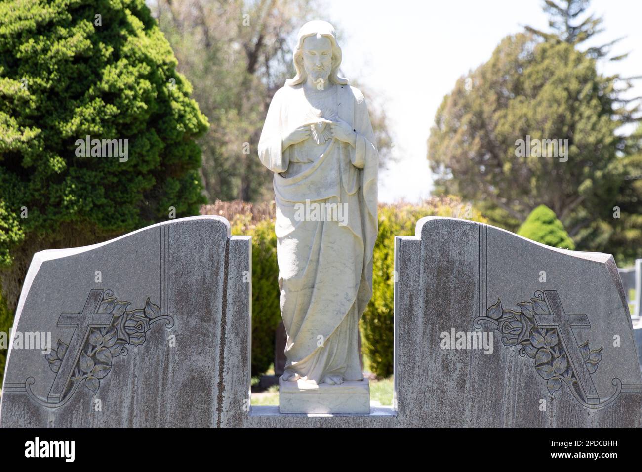 Stone statue of Jesus Christ pointing at His Sacred Heart on a ...