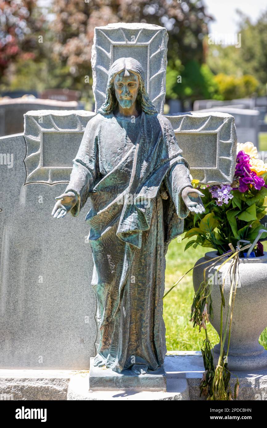 Statue of Jesus Christ holding out his hands in front of a cross on a ...