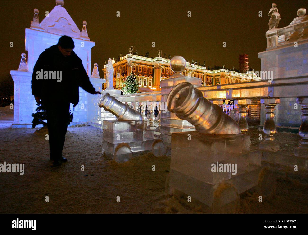 A man touches an ice cannon at the Ice Palace, with the Winter Palace ...