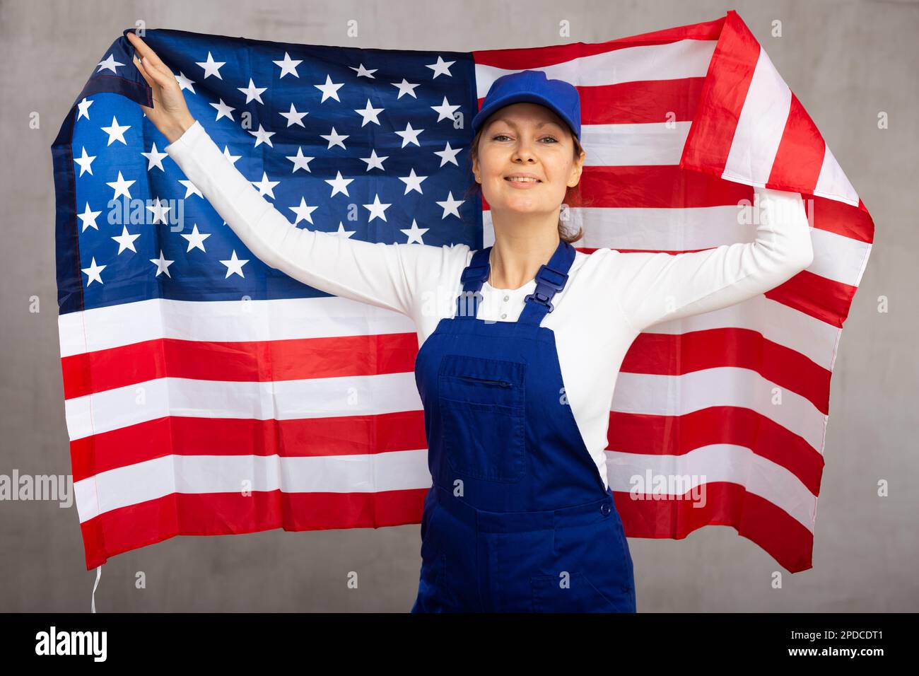 Smiling adult woman in uniform holding USA flag Stock Photo - Alamy