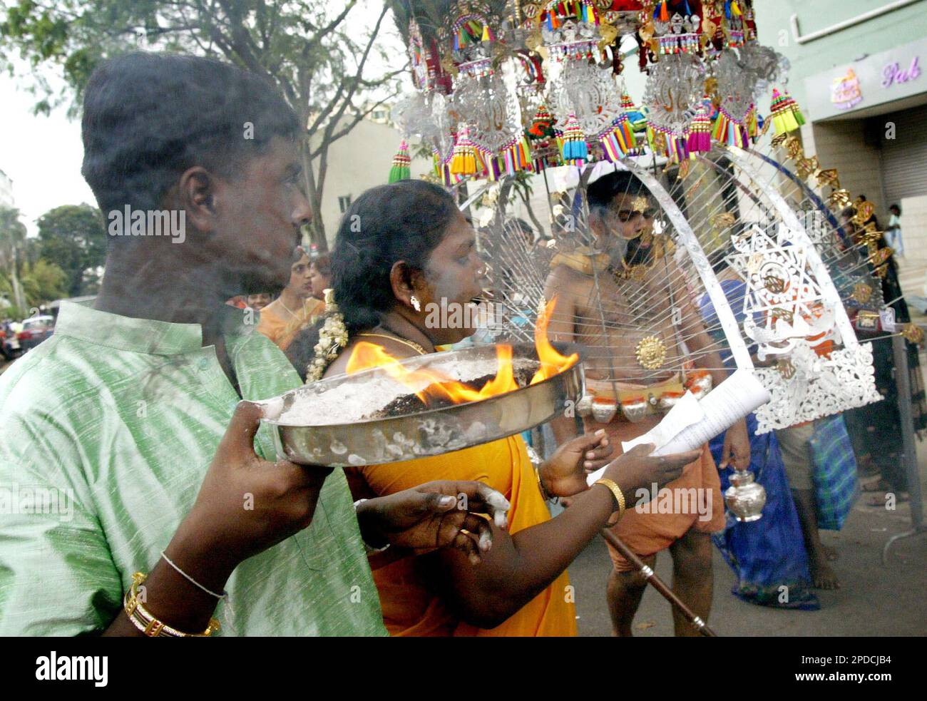 A Hindu devotee carries a Kavadi, comprising of a metal frame suspended ...