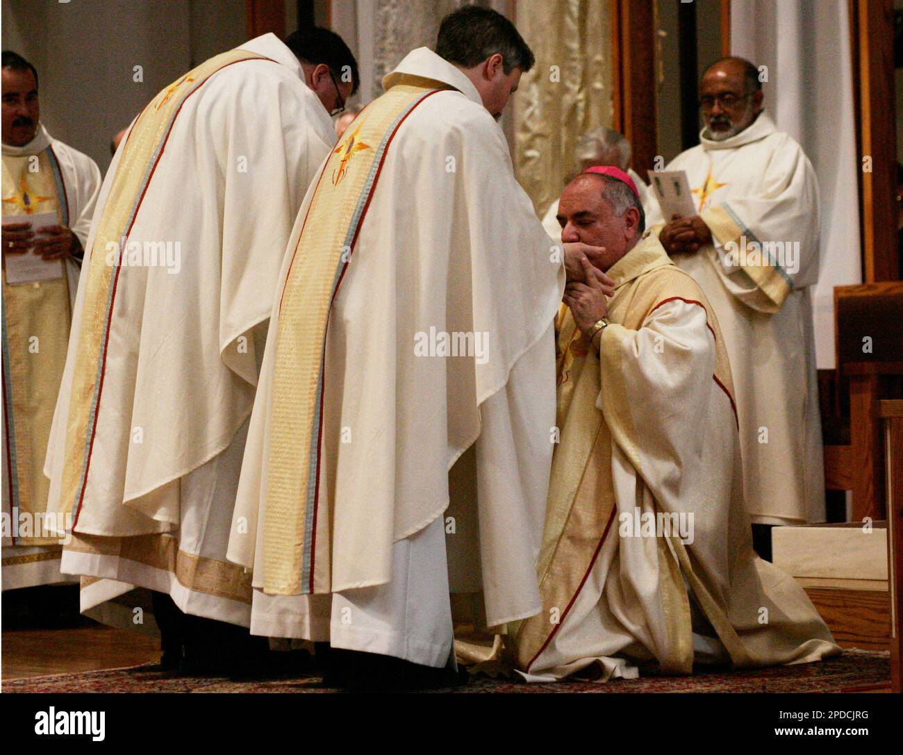 San Bernardino Bishop Gerald Barnes kisses the hands of Father Gregory ...