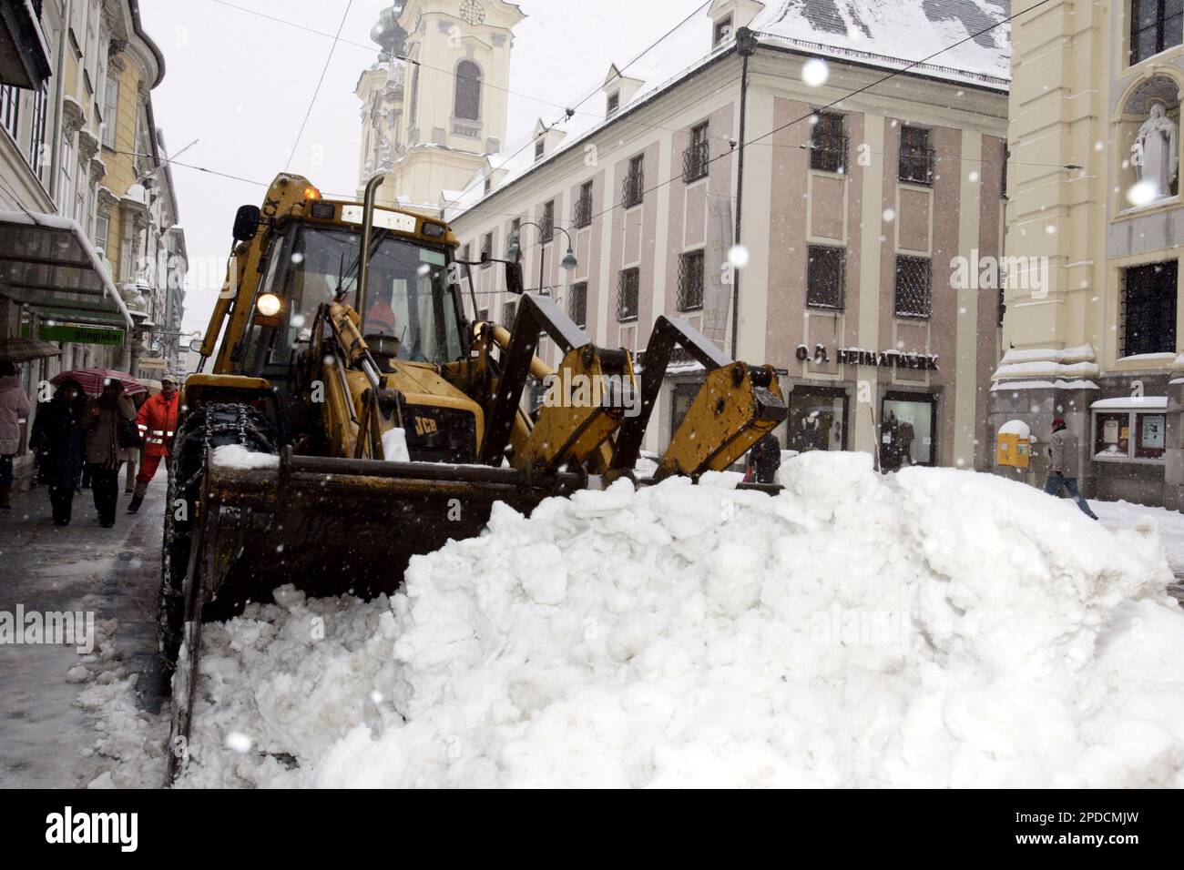 A heavy snowplow struggles with a pile of snow at the main shopping ...