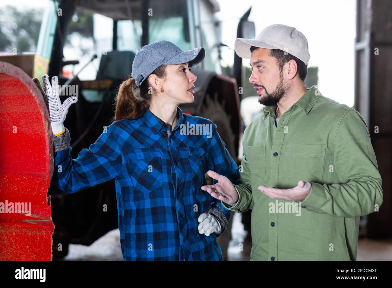 Man and woman farmers talking near tractor Stock Photo - Alamy