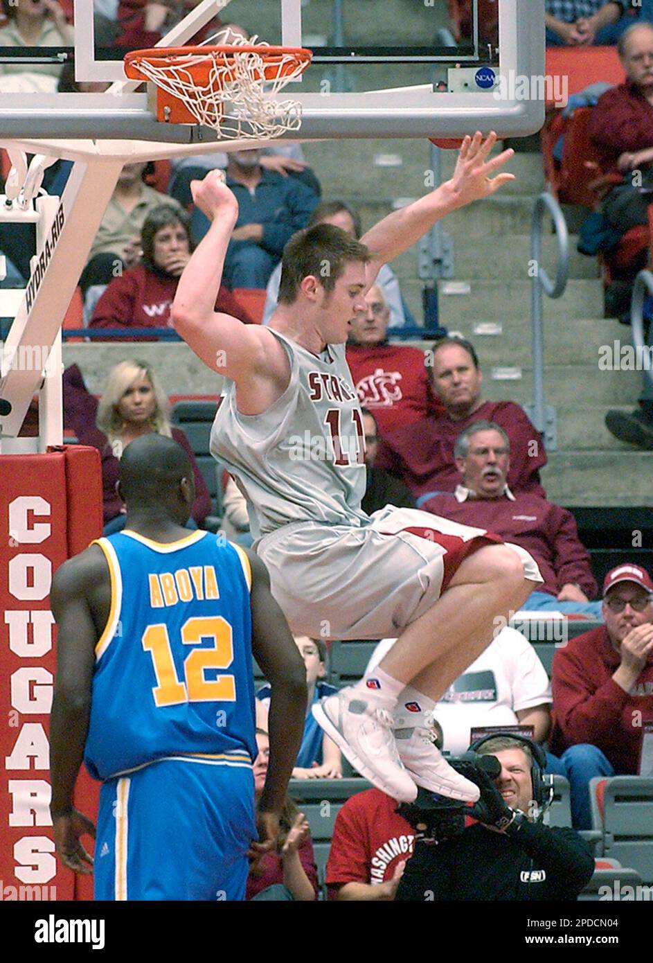 Washington State's Aron Baynes, right, drops from the rim after a slam ...