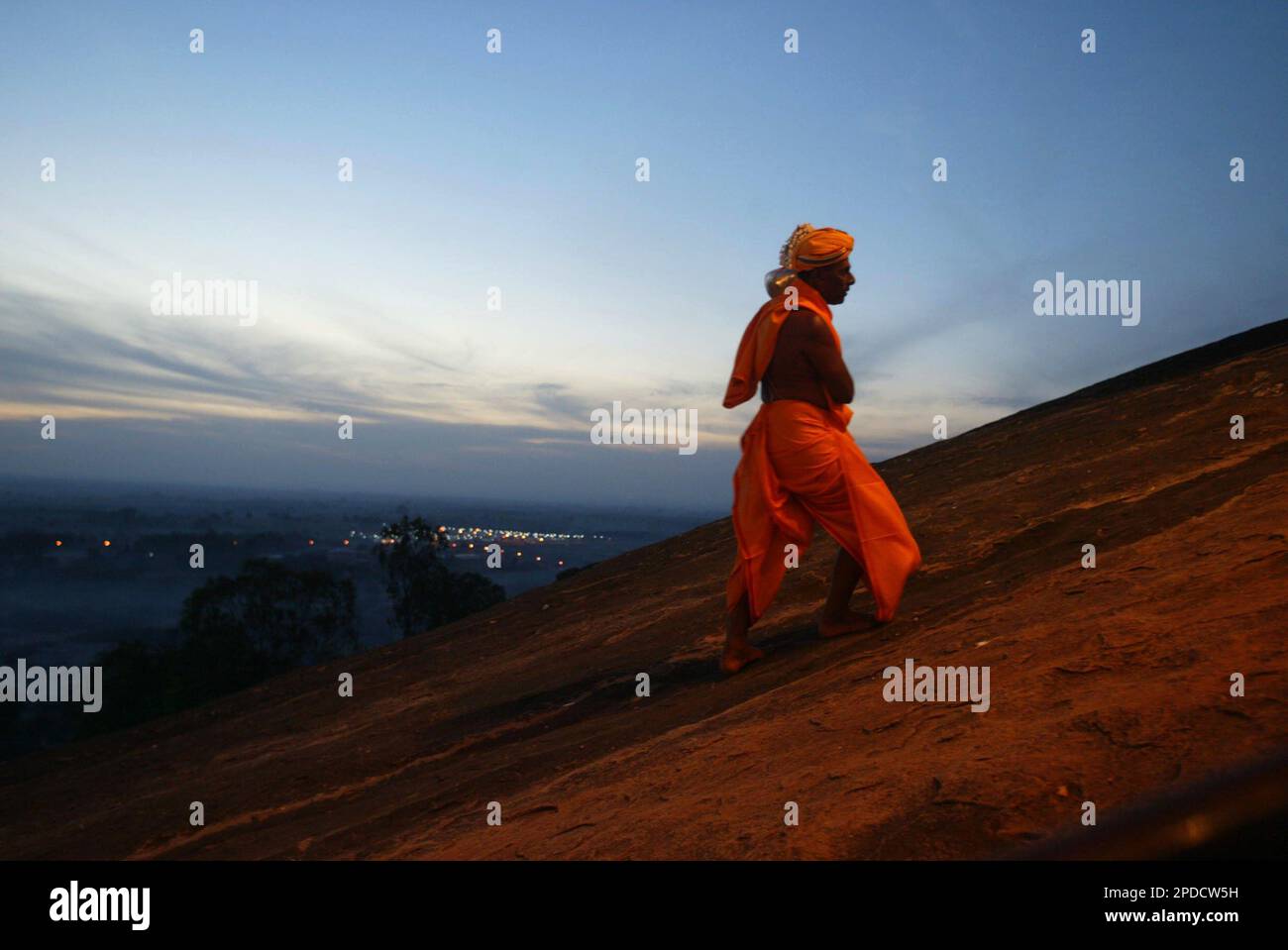 A priest carries holy water to the complex of the 58.8 foot monolithic ...