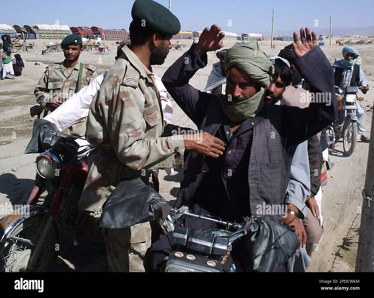 A Pakistani border guard checks Afghan nationals entering Pakistan ...