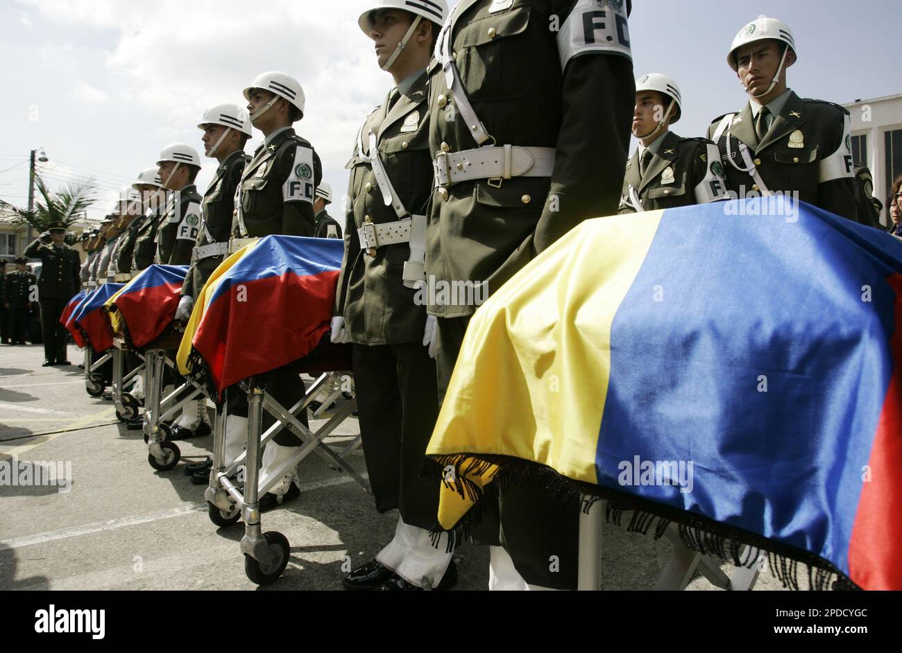 Police officers accompany coffins during the funeral of six of seven ...